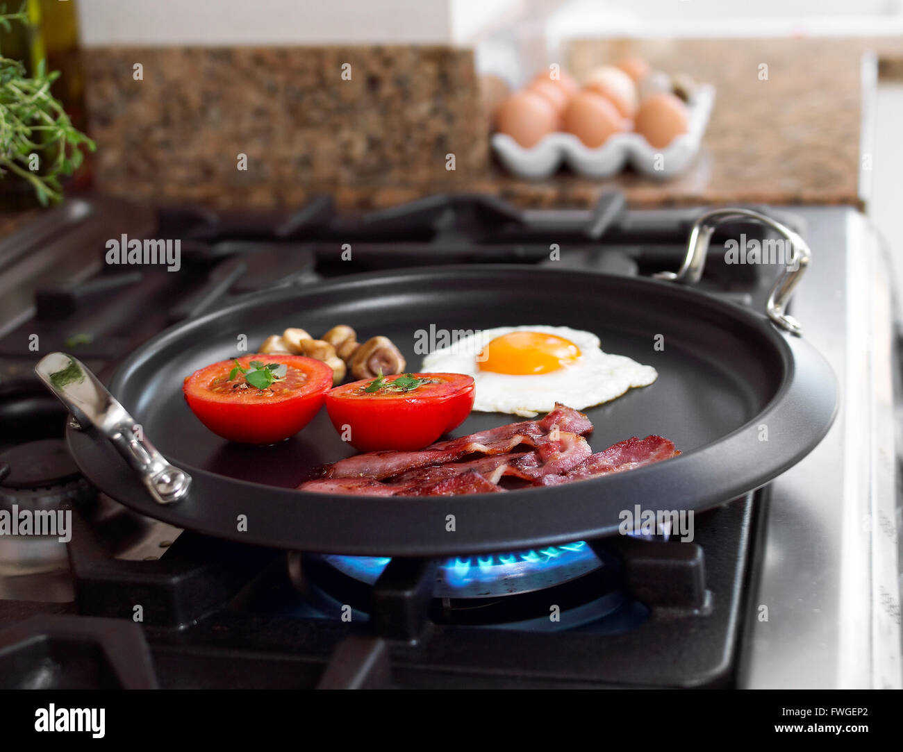 Cooking a typical English breakfast on a gas stove Stock Photo - Alamy
