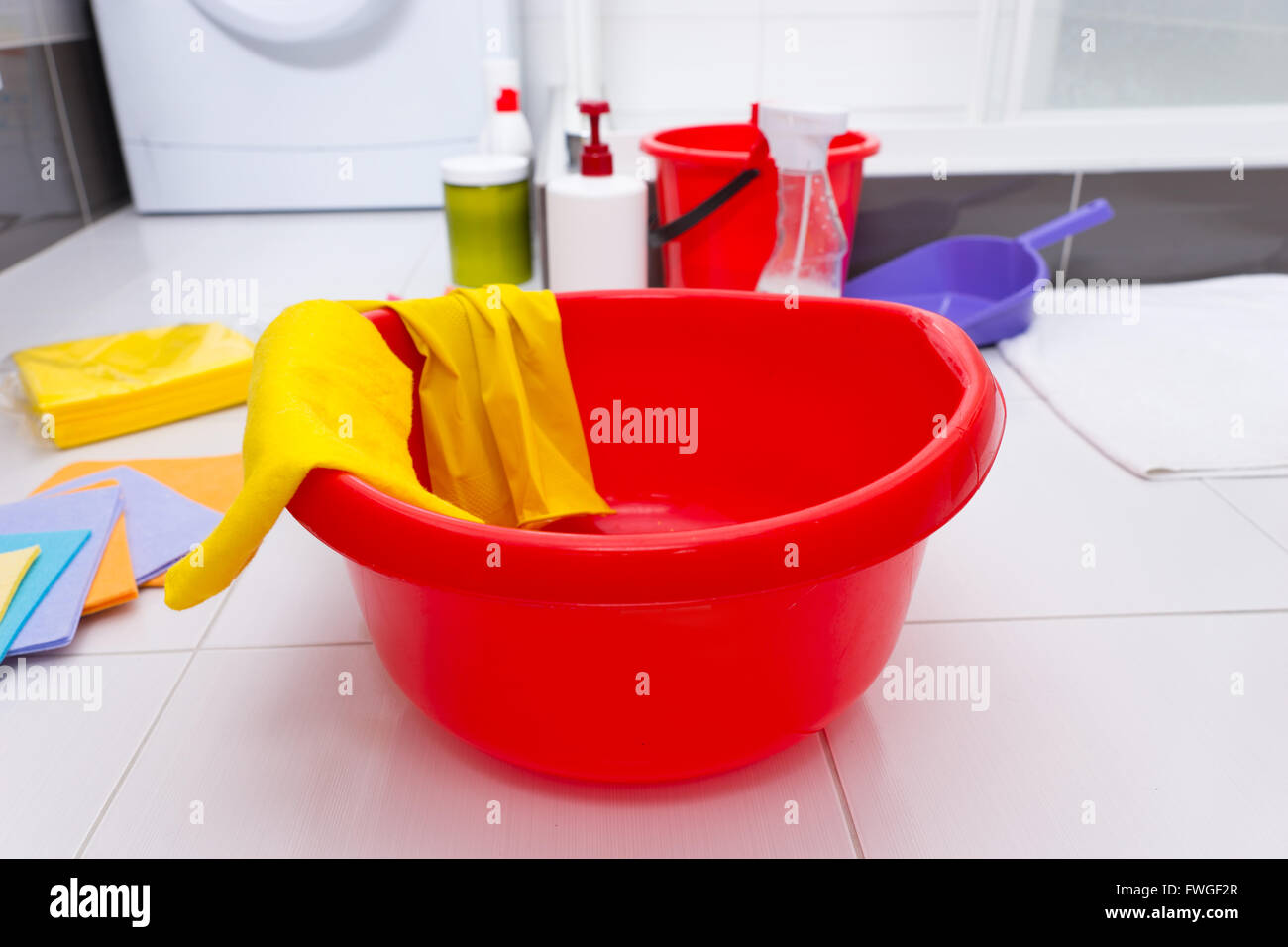 Colorful collection of household cleaning products with a red basin ...
