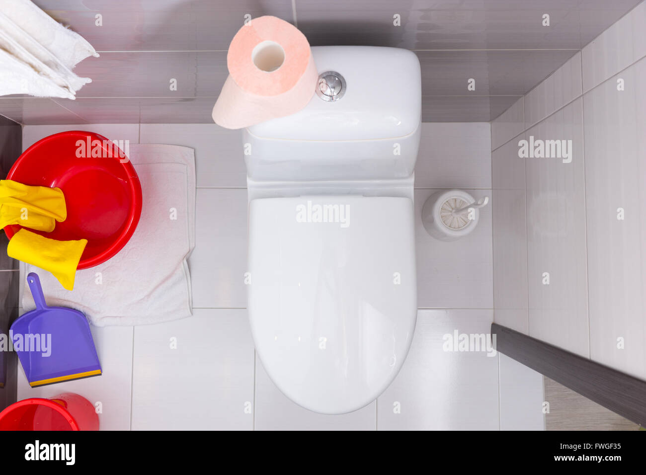 Overhead view of a toilet with a colorful array of assorted household ...