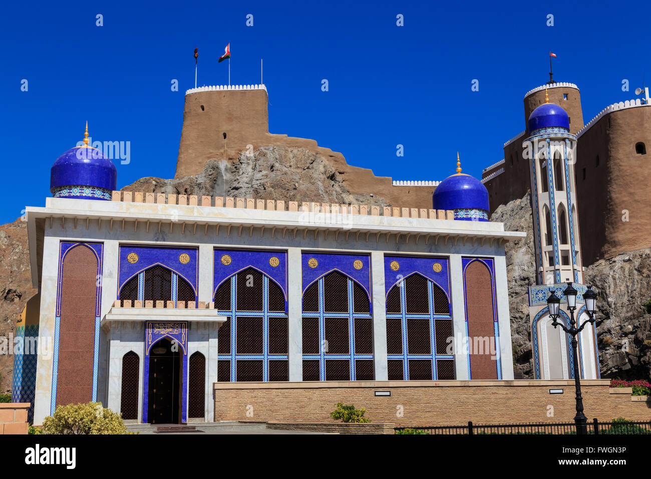 Blue domed mosque with minaret and Al-Mirani Fort, Old Muscat, Oman ...