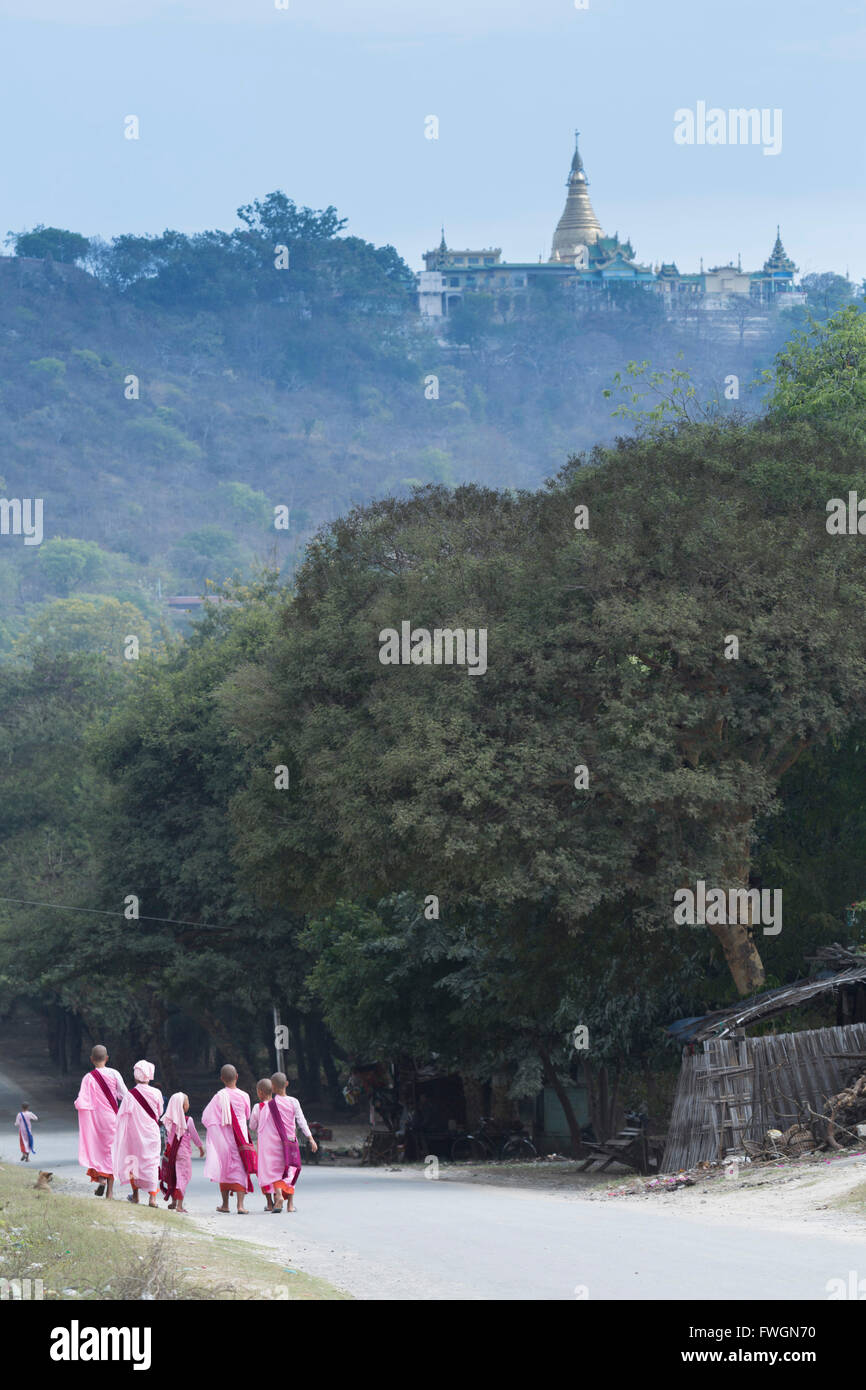 Buddhist nuns in traditional robes with the stupas of Sagaing in the ...