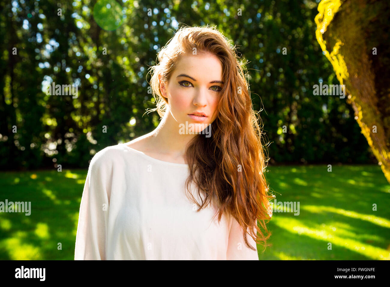 A beautiful young girl poses for a fashion style portrait outdoors at a ...