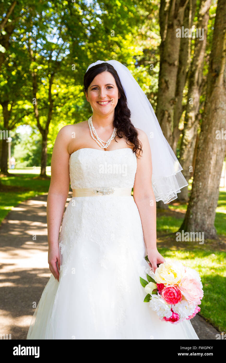 A bride poses for some portraits while wearing her wedding dress at a ...