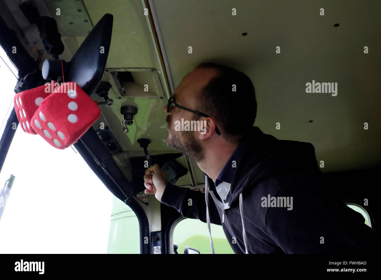 man changing a bus destination board at a show of classic vintage buses ...