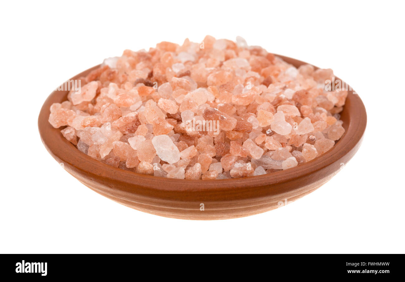A portion of Himalayan pink salt in a small bowl isolated on a white ...