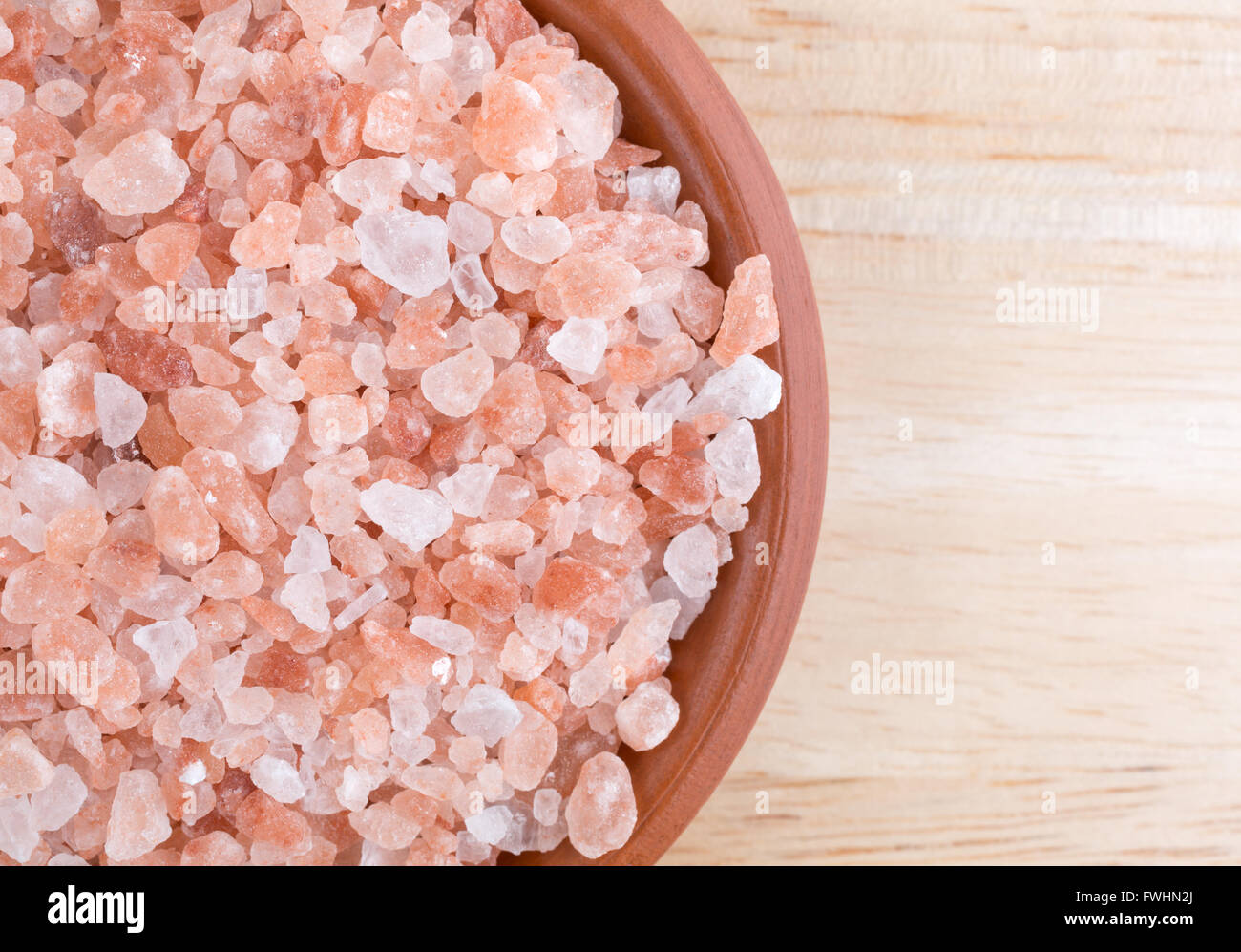Top close view of a portion of Himalayan pink salt in a small bowl on a ...
