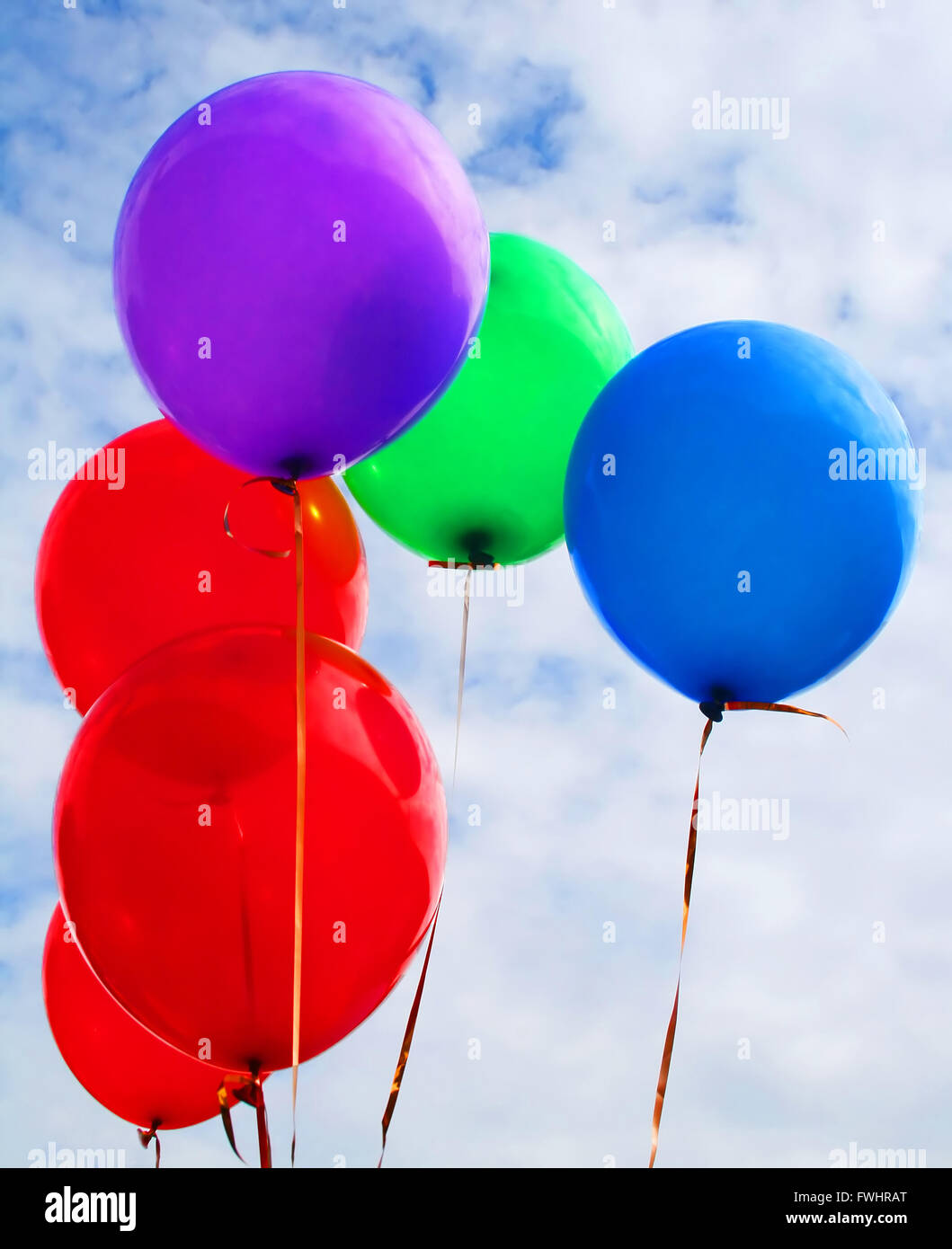Coloured balloons floating in a cloudy sky Stock Photo - Alamy