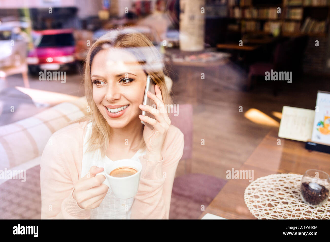Woman in cafe drinking coffee, making a phone call Stock Photo - Alamy