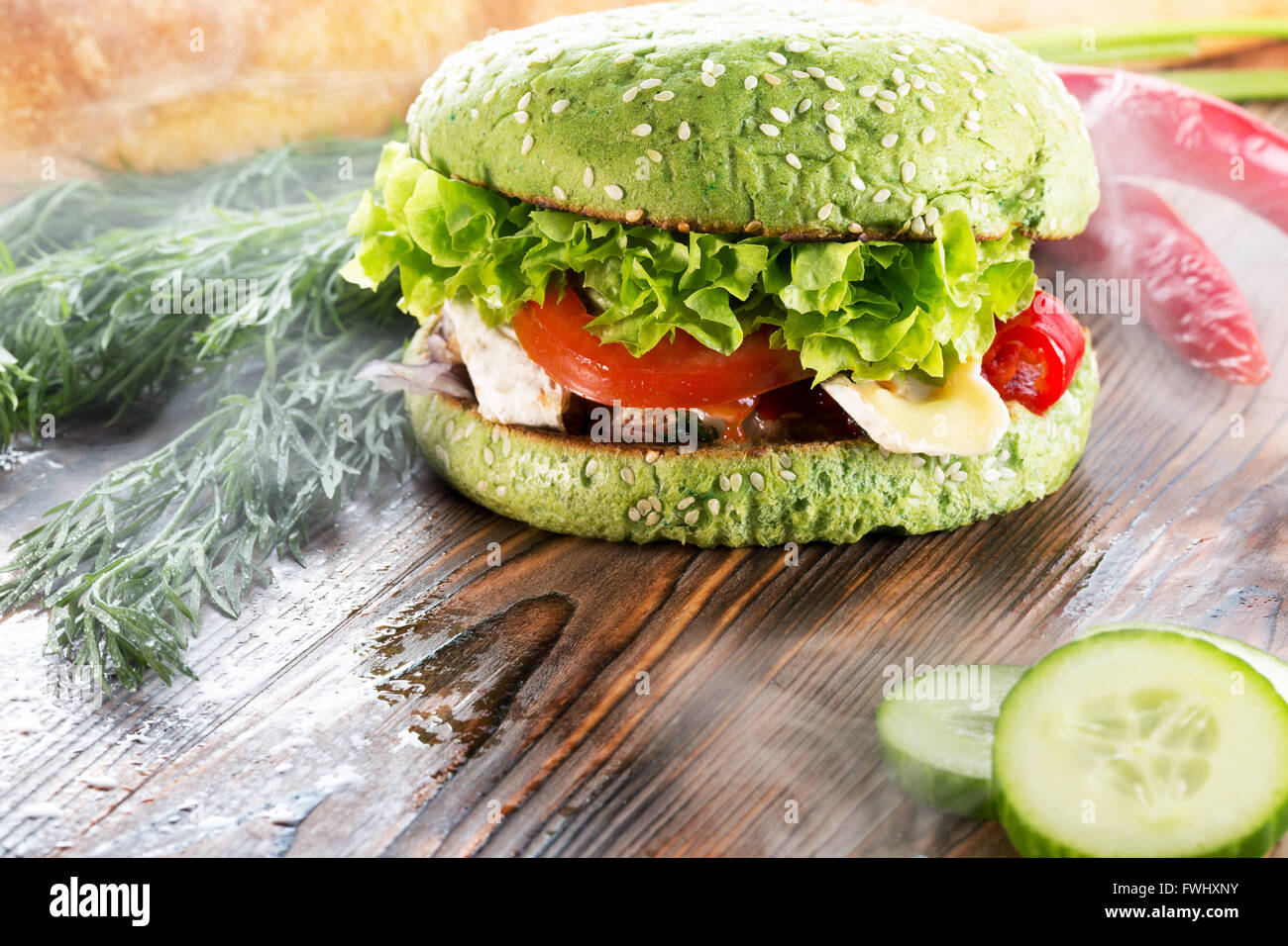 burger with green bun in light smoke on wooden background Stock Photo ...