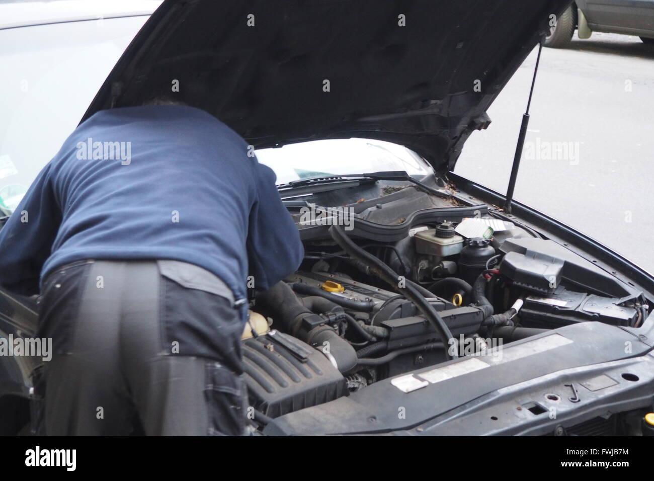 Rear View Of Mechanic Repairing Car Stock Photo - Alamy