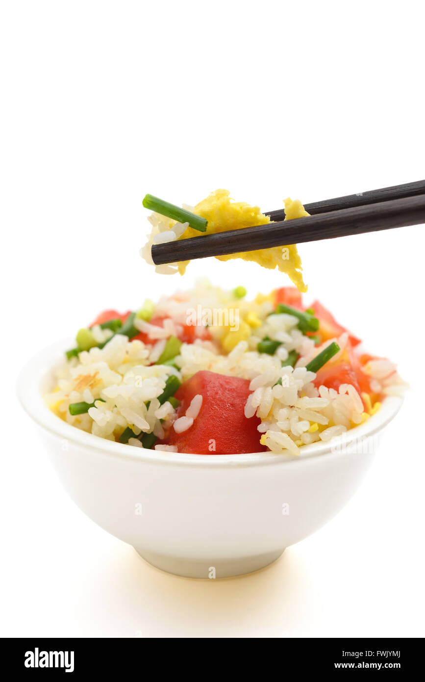 chopsticks picking up fried rice and egg on white with clipping path ...