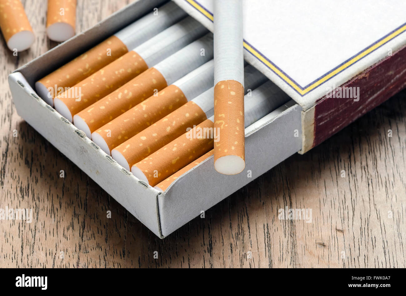 Tobacco cigarette in the box of matches on wooden background Stock ...