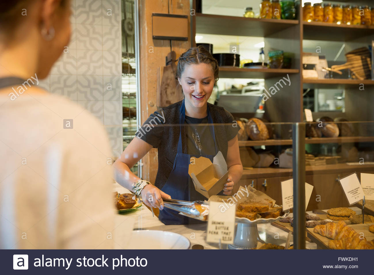 Woman smiling behind bakery counter High Resolution Stock Photography ...