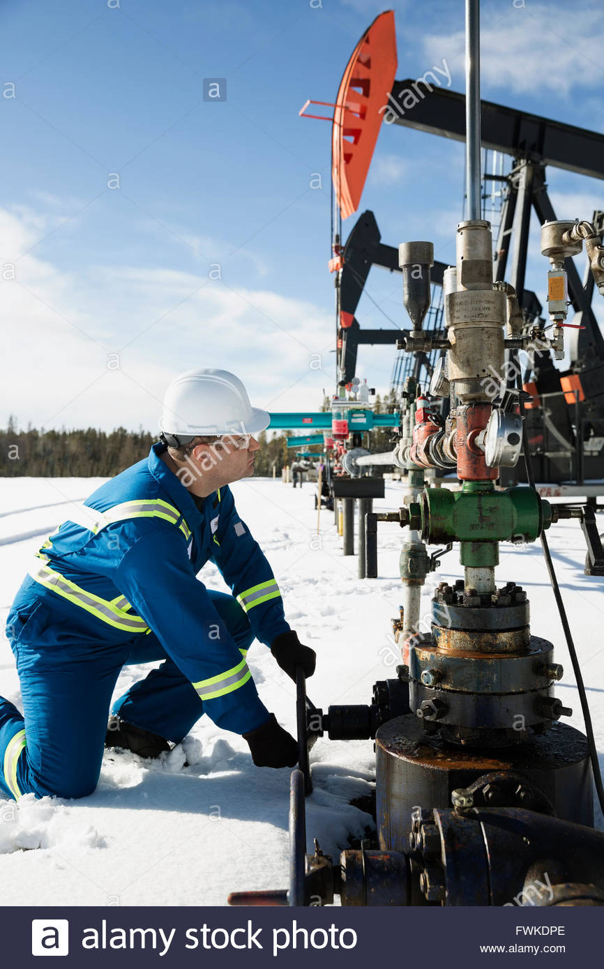 Male worker turning drilling rig valve in snow Stock Photo - Alamy