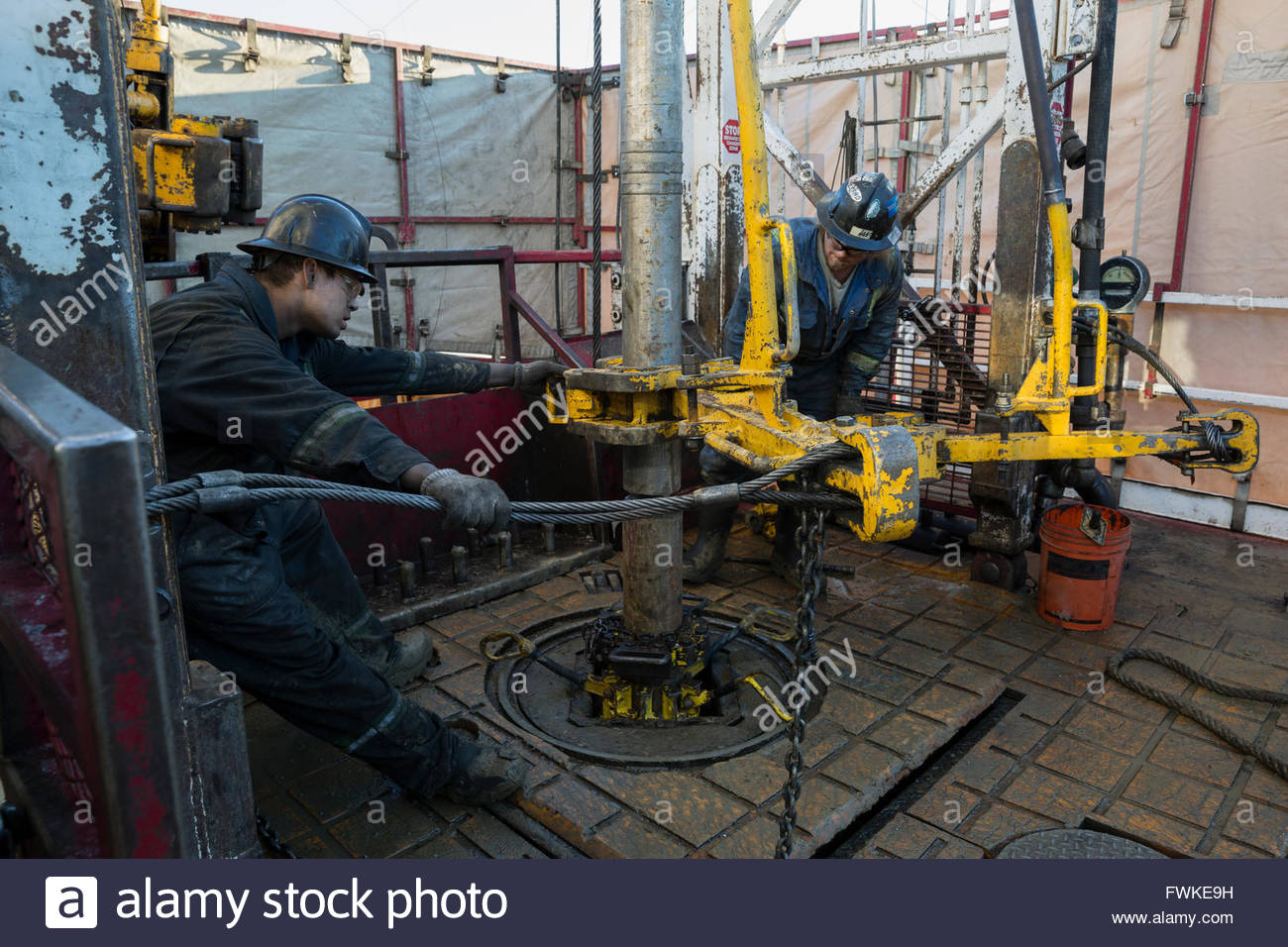 Male workers working drilling rig equipment gas plant Stock Photo - Alamy