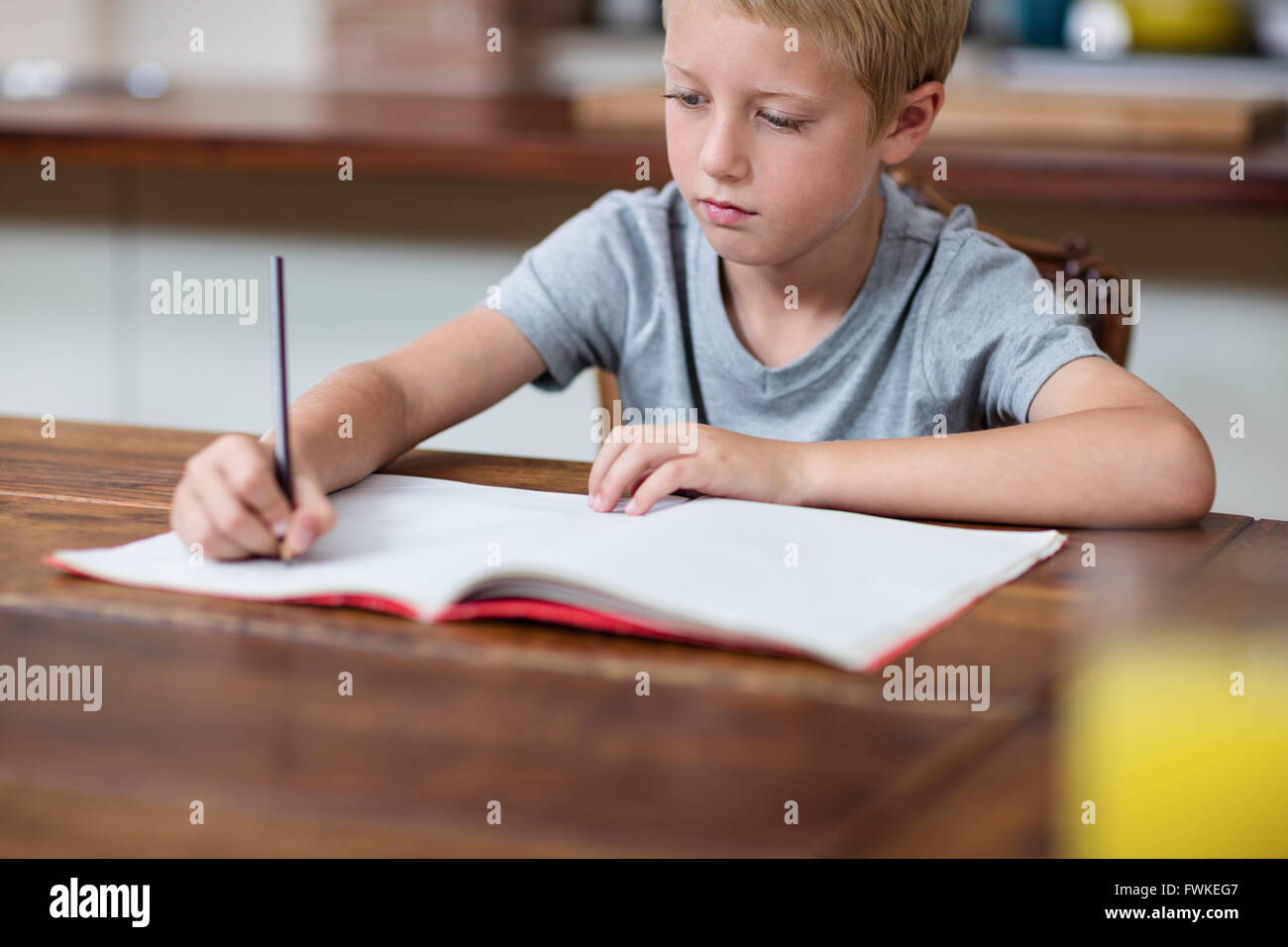 Boy doing homework in kitchen Stock Photo - Alamy
