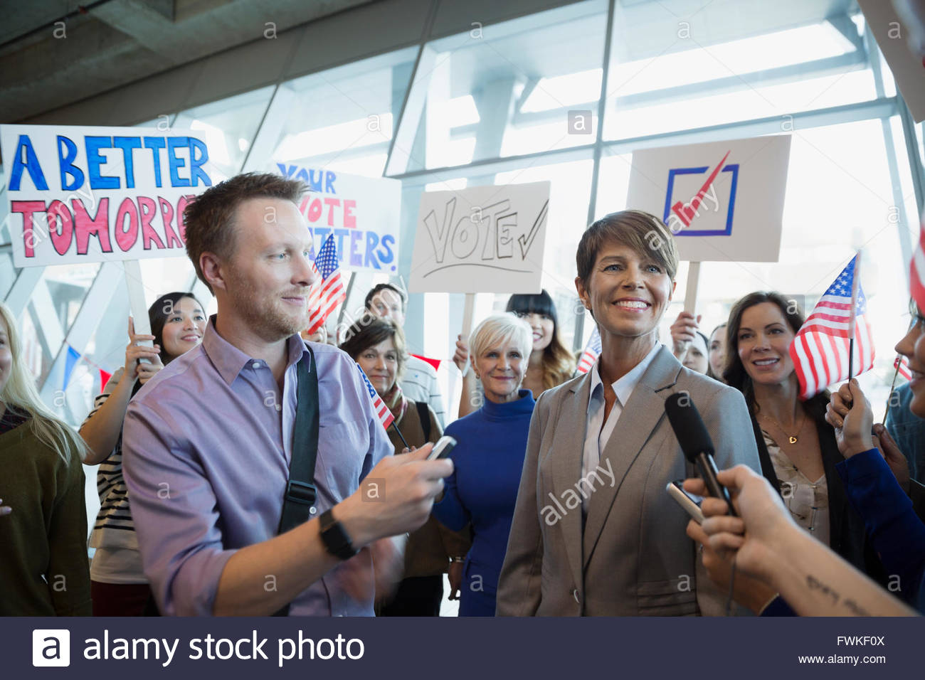 Female politician being interviewed among crowd at rally Stock Photo ...