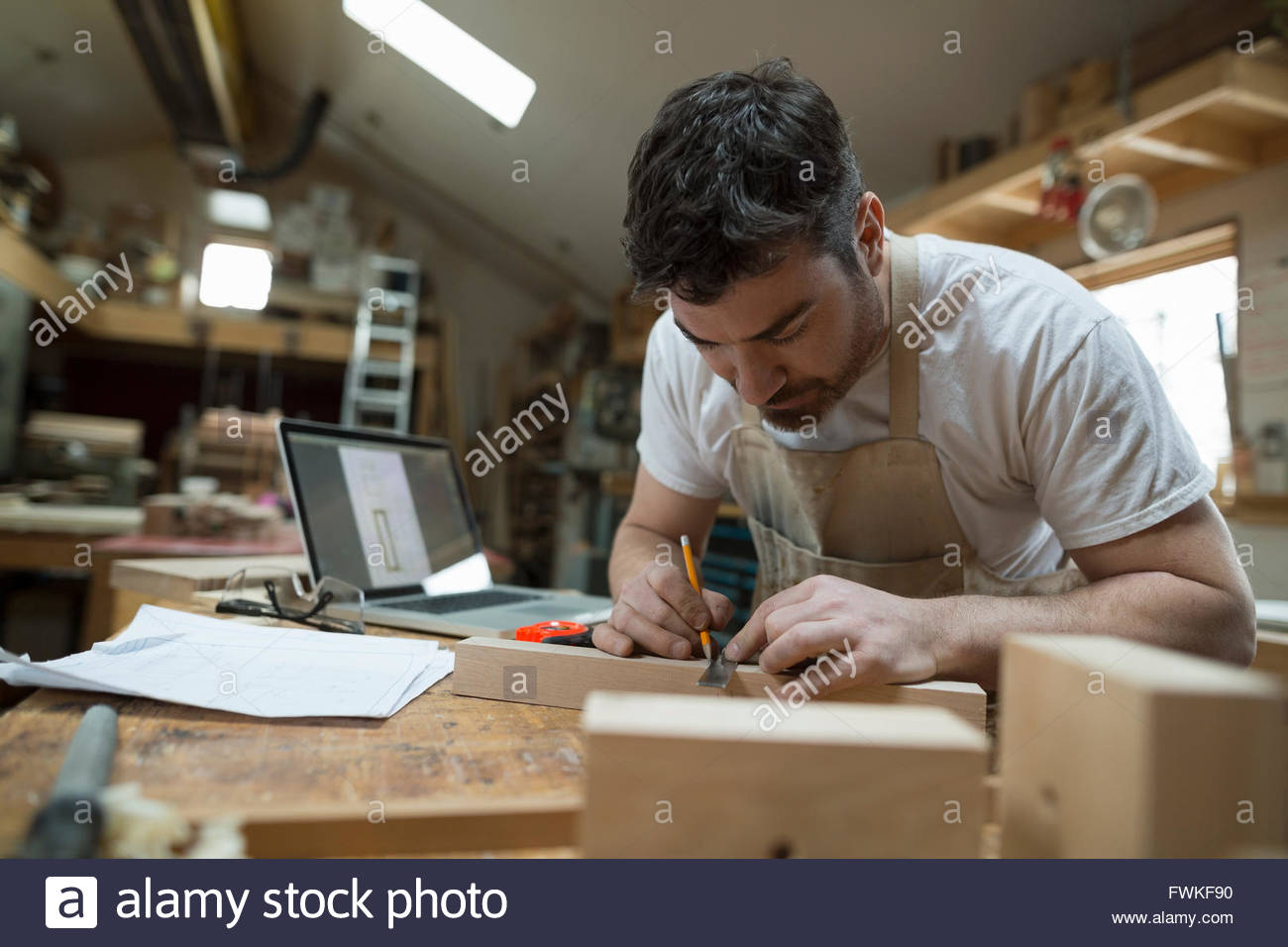 Carpenter marking wood block in workshop Stock Photo - Alamy