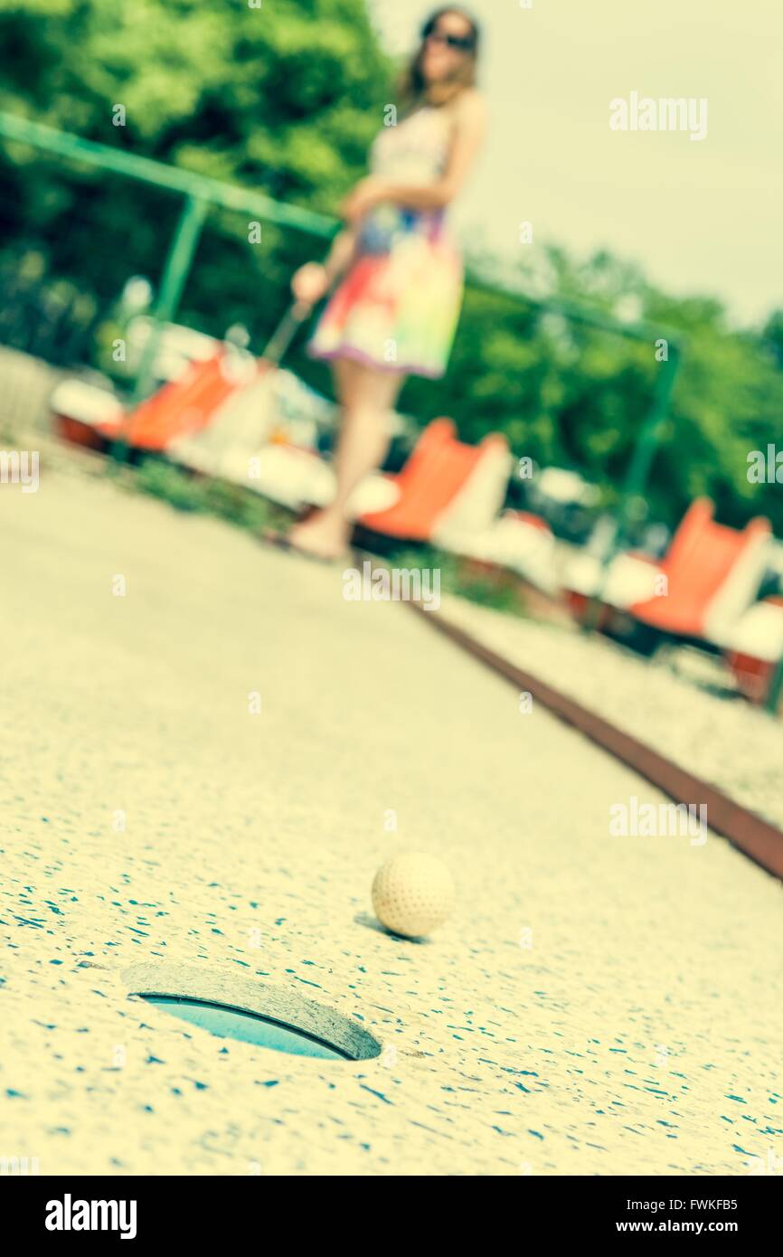 Attractive young woman playing mini golf Stock Photo - Alamy