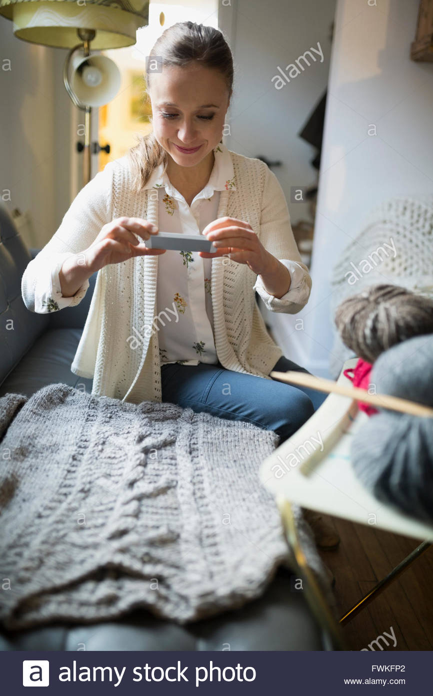 Woman photographing homemade knit sweater with camera phone Stock Photo ...