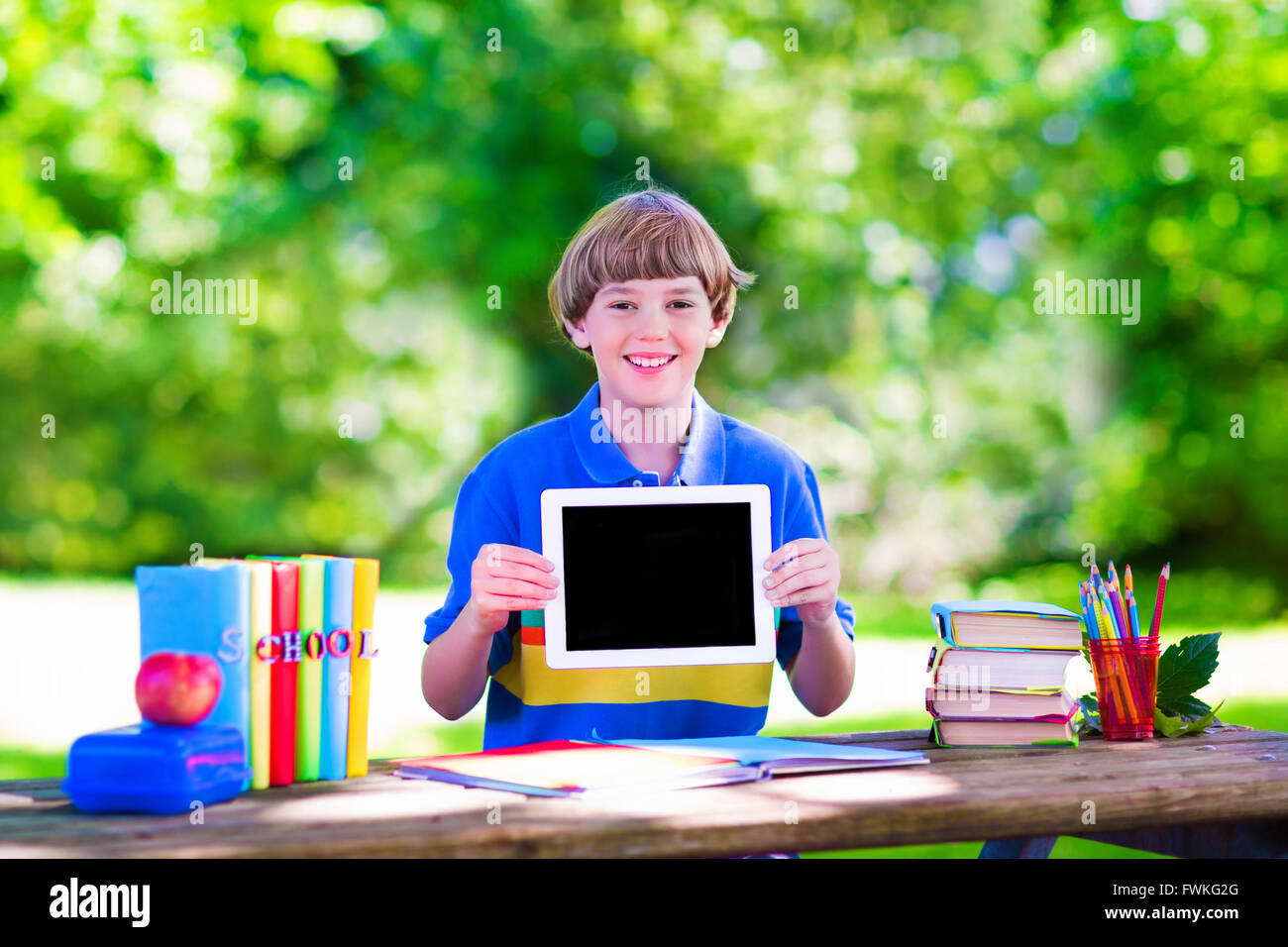 Child in school with tablet pc. Smart teenager student boy studying and ...