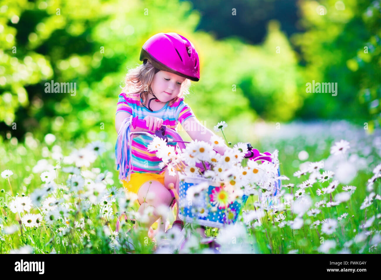 Happy child riding a bike. Cute kid in safety helmet biking outdoors ...