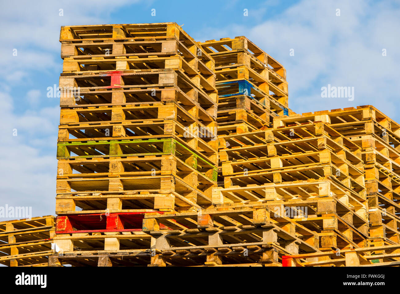 A large pile of wooden pallets sitting in the sunlight Stock Photo - Alamy