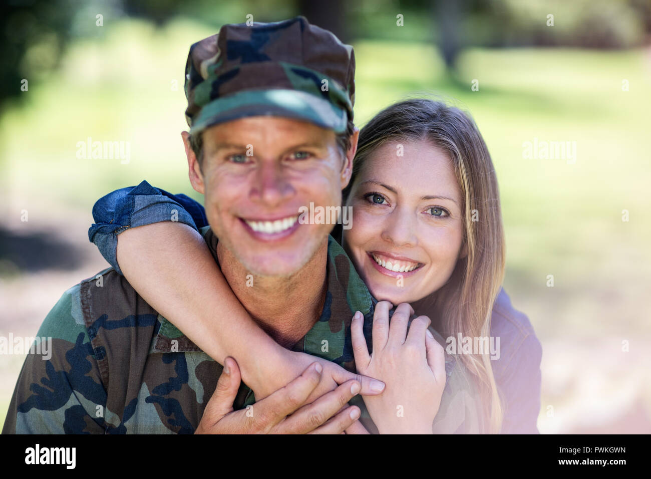 Happy soldier reunited with his partner in the park Stock Photo - Alamy