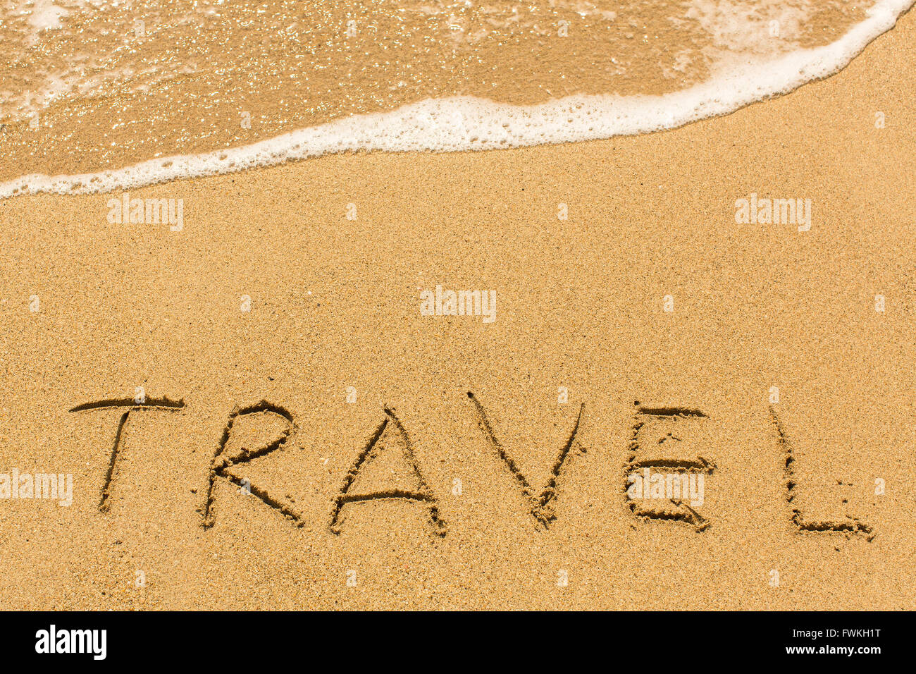 Travel - written manually on the texture of sea sand, with the wave ...