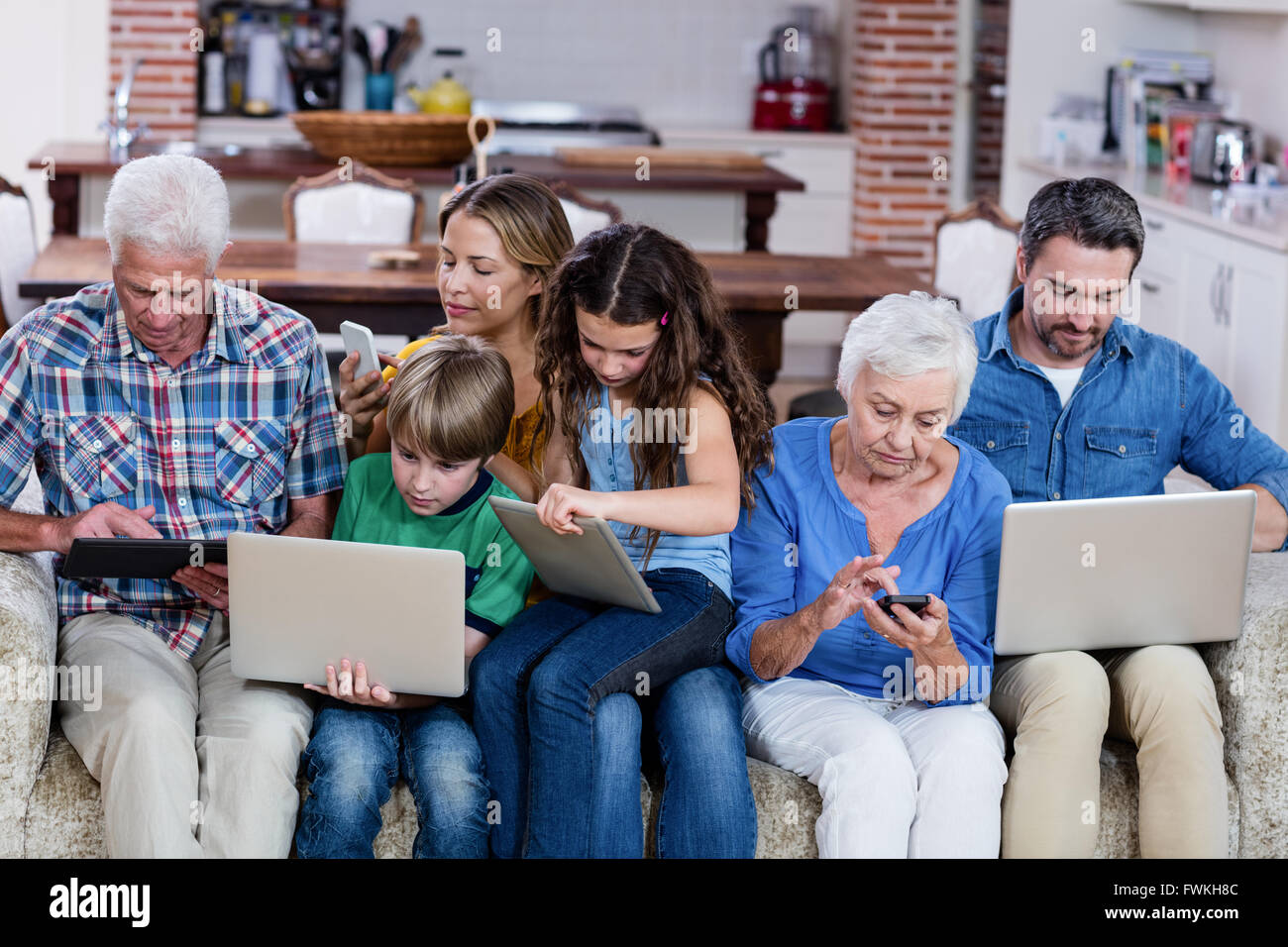 Multi-generation family using a laptop, tablet and phone Stock Photo ...