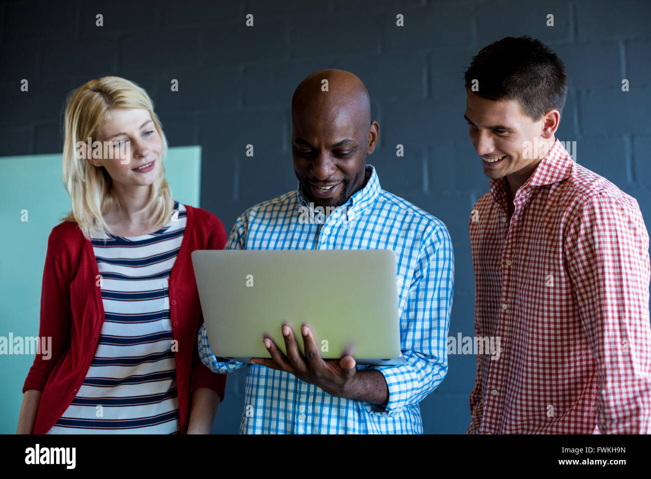 Colleagues discussing using laptop Stock Photo - Alamy