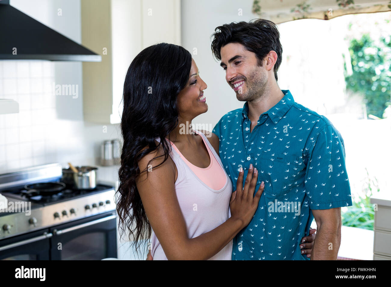 Young couple embracing face to face in kitchen Stock Photo - Alamy
