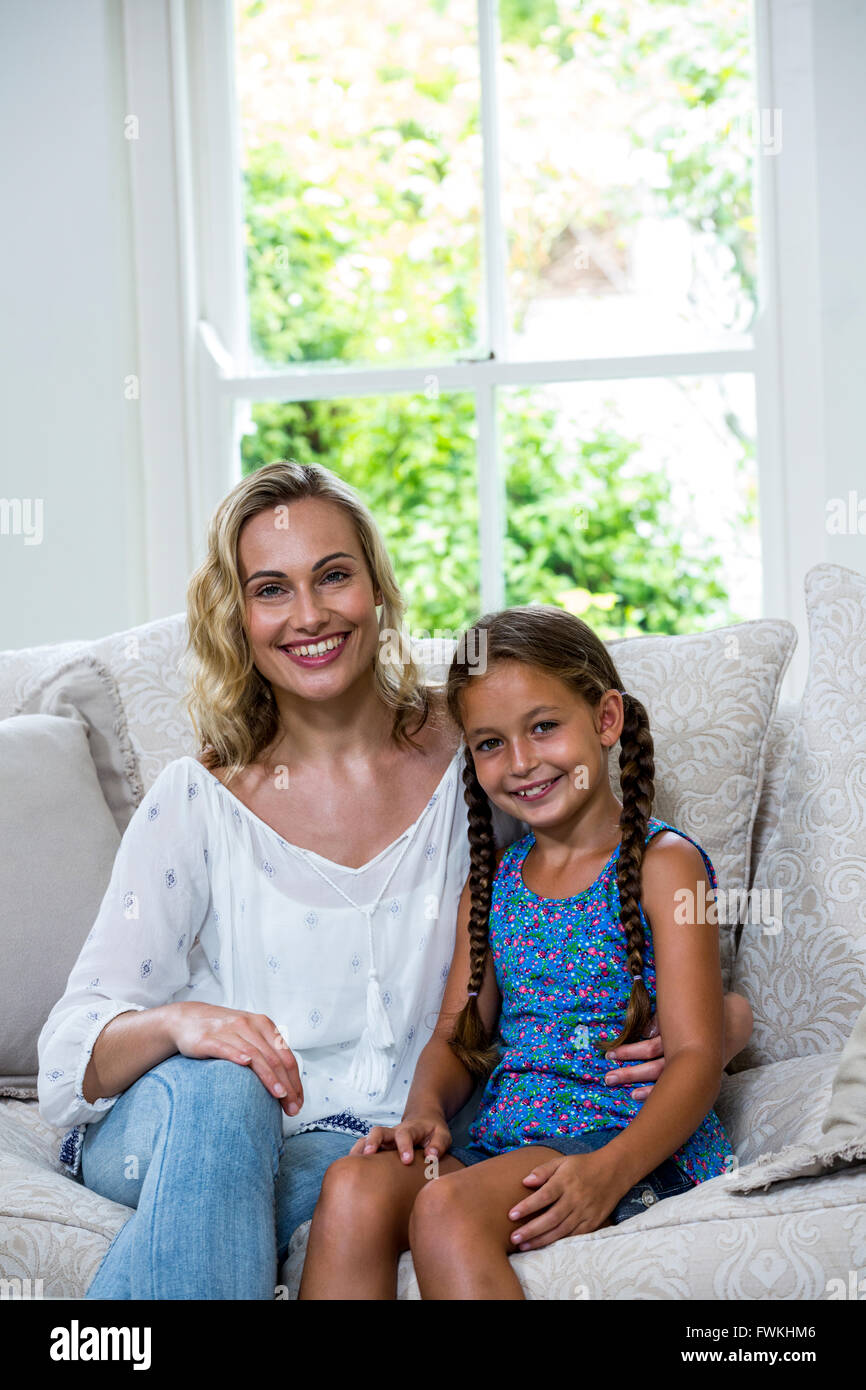 Portrait of mother and daughter sitting on sofa Stock Photo - Alamy