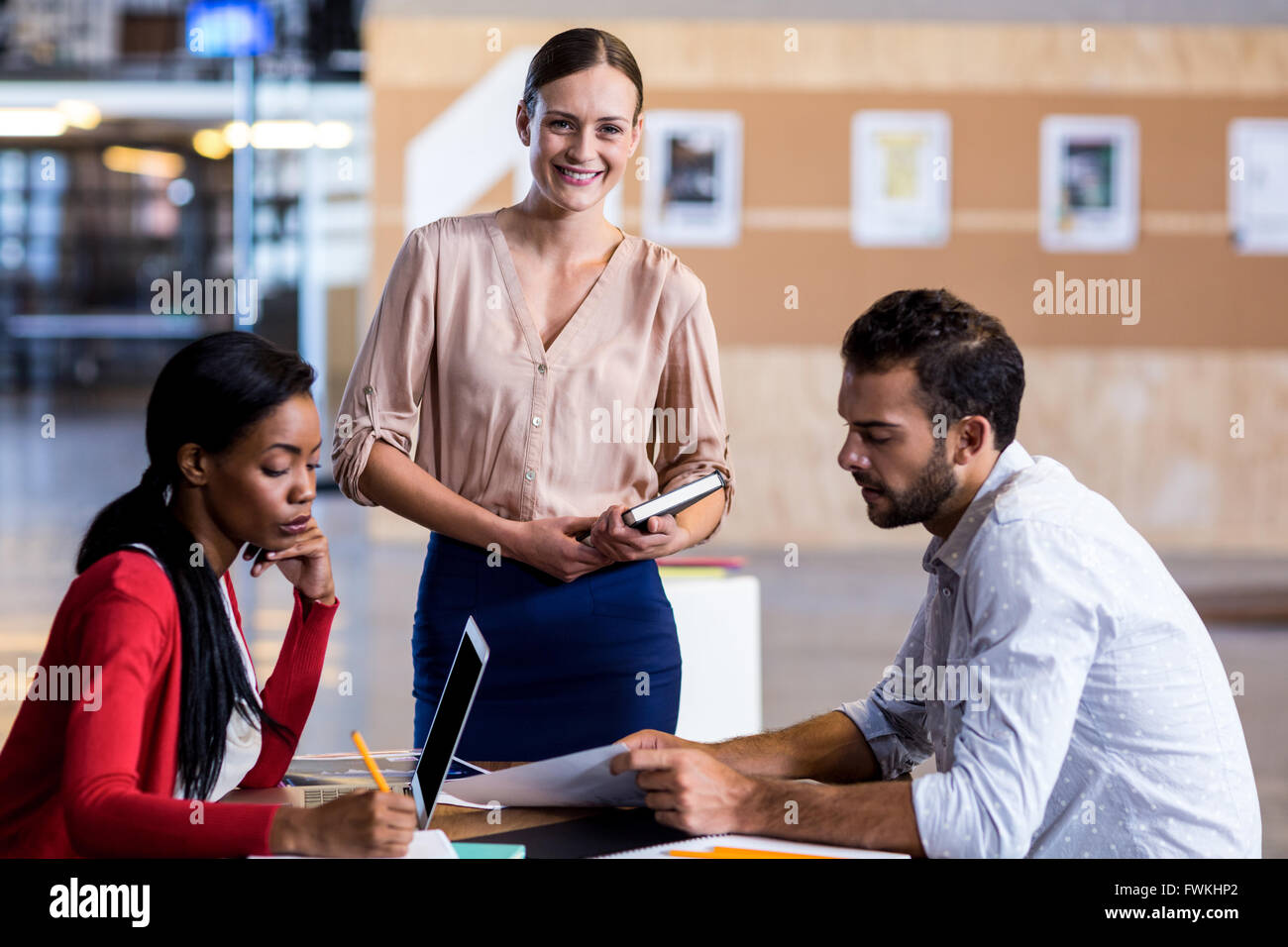 Team of colleagues writing notes at their desk Stock Photo - Alamy