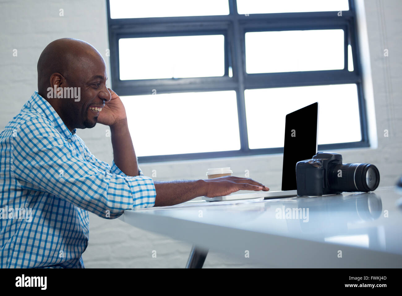 Man talking on mobile phone while using laptop Stock Photo - Alamy