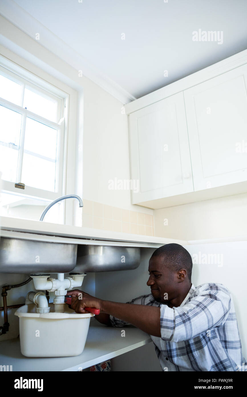 Man repairing a kitchen sink Stock Photo - Alamy