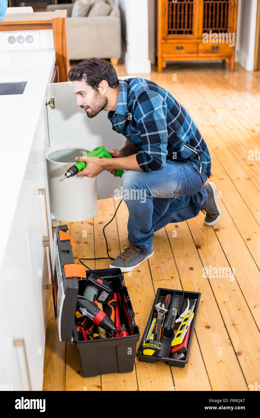 Man drilling a hole inside the cabinet Stock Photo - Alamy