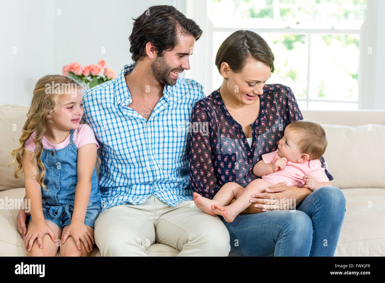 Family sitting on sofa at home Stock Photo - Alamy
