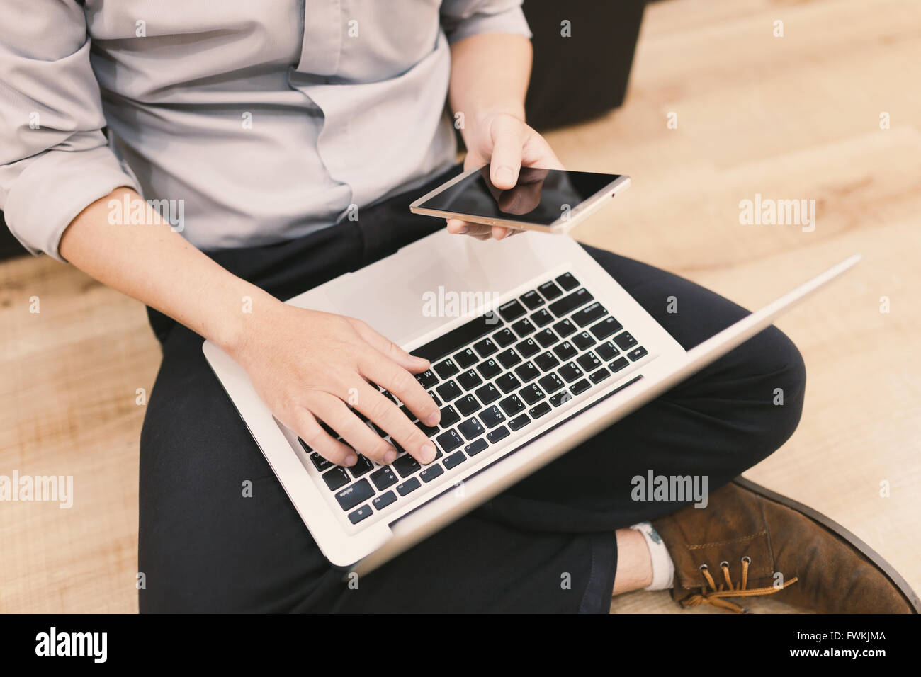 Top view man typing text message on his smart phone while sitting front ...