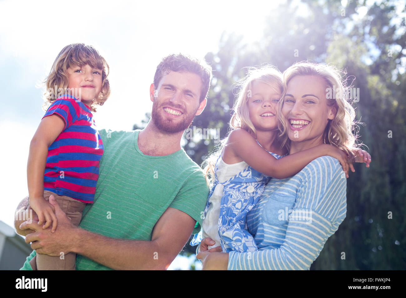 Smiling parent carrying children Stock Photo - Alamy