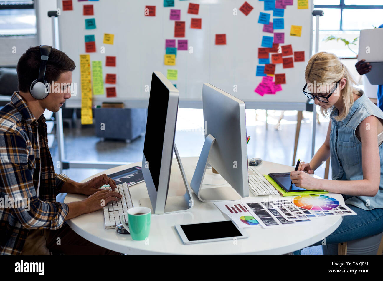 Graphic designers working at their desk Stock Photo - Alamy