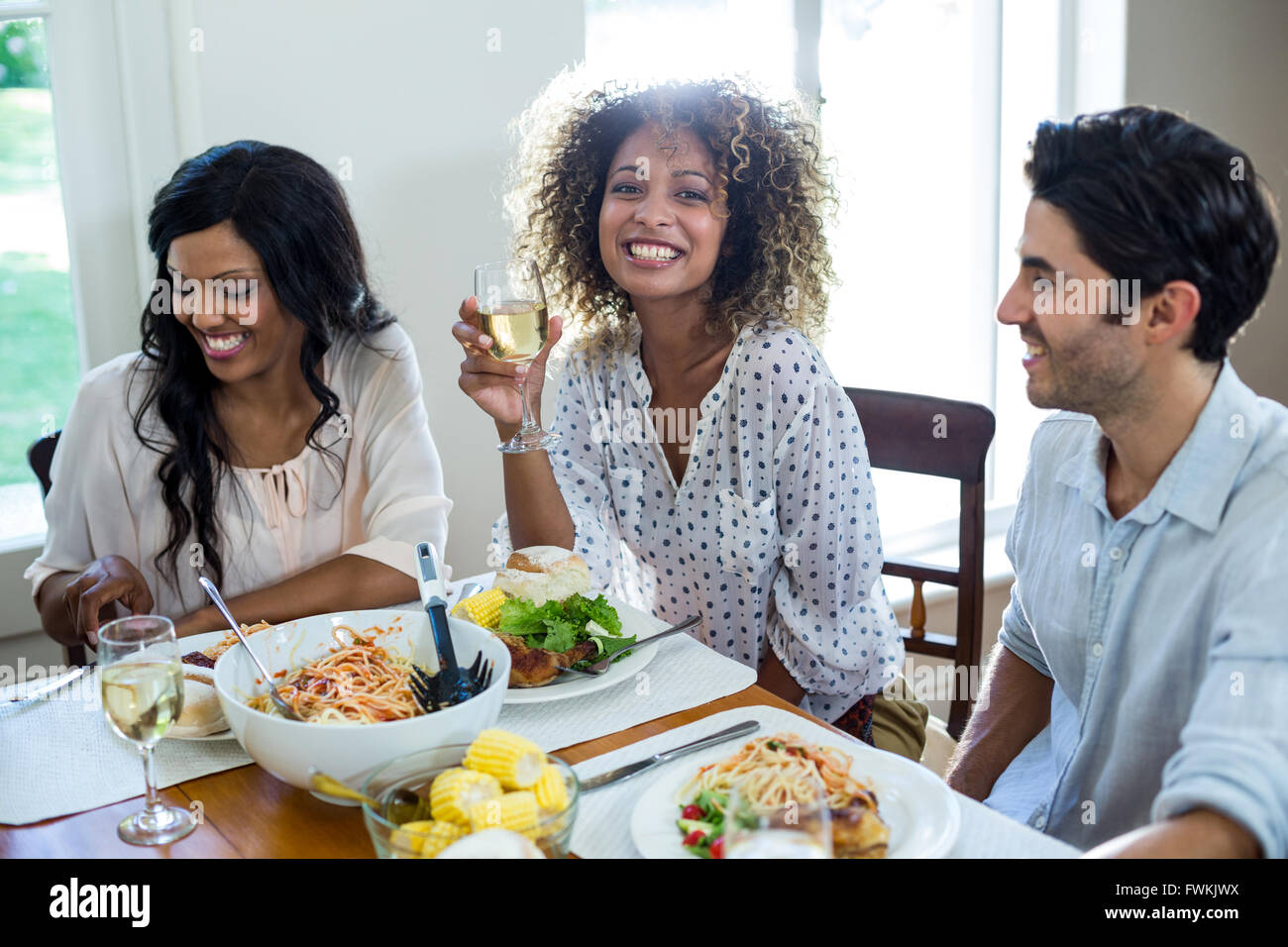 Happy friends having meal together Stock Photo - Alamy