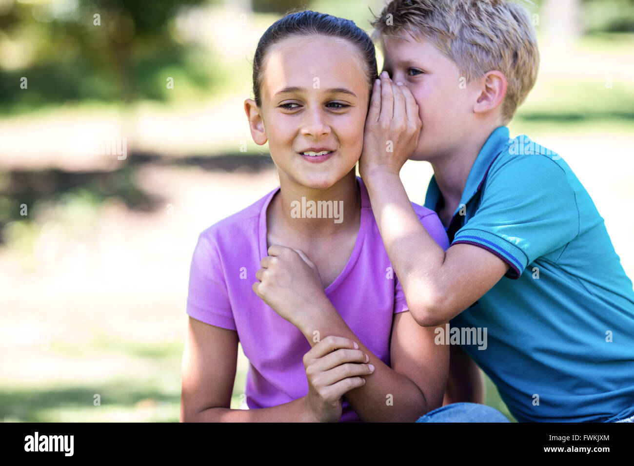 Brother whispering in his sisters ear Stock Photo - Alamy