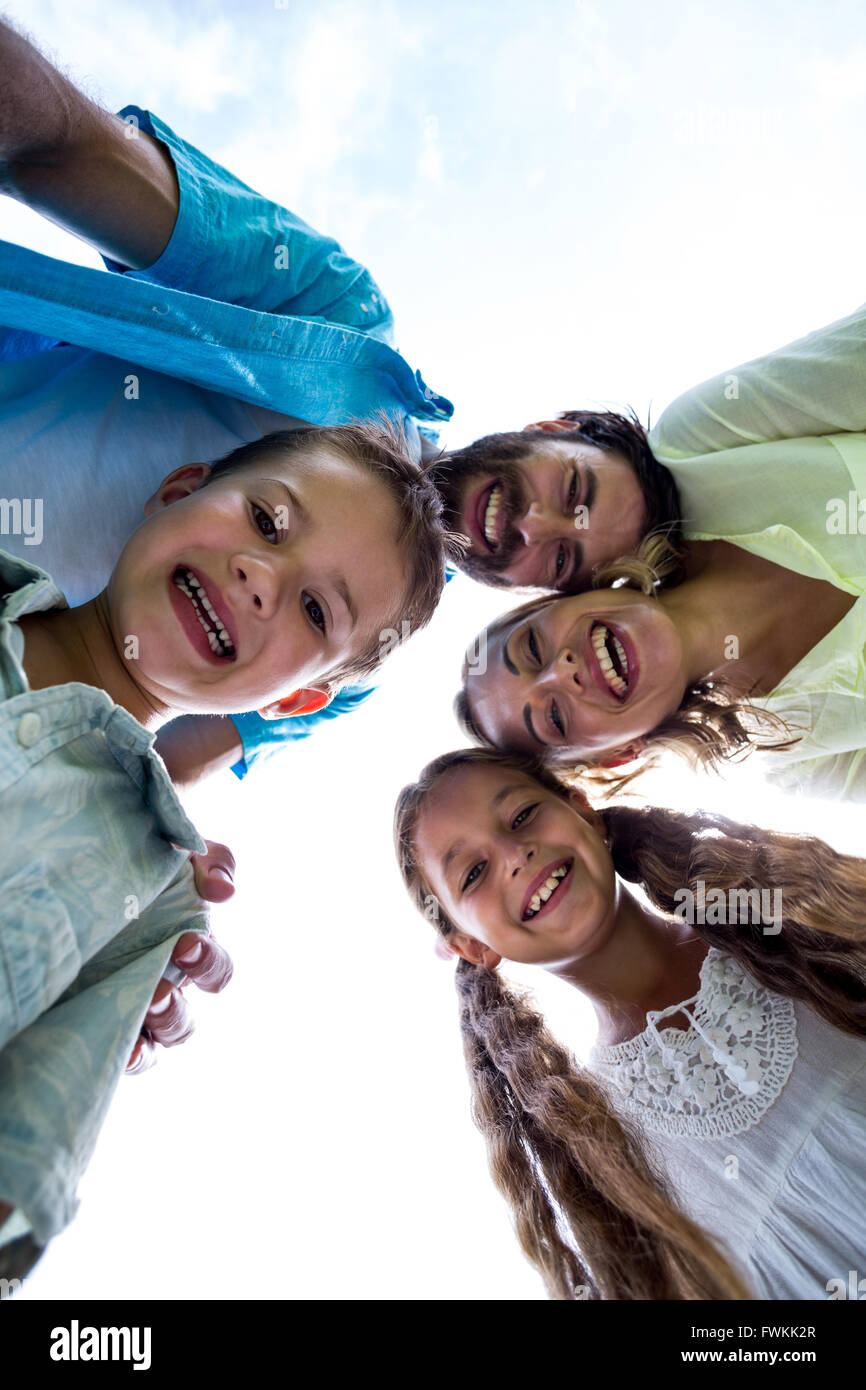 Cheerful family forming huddle against sky Stock Photo - Alamy