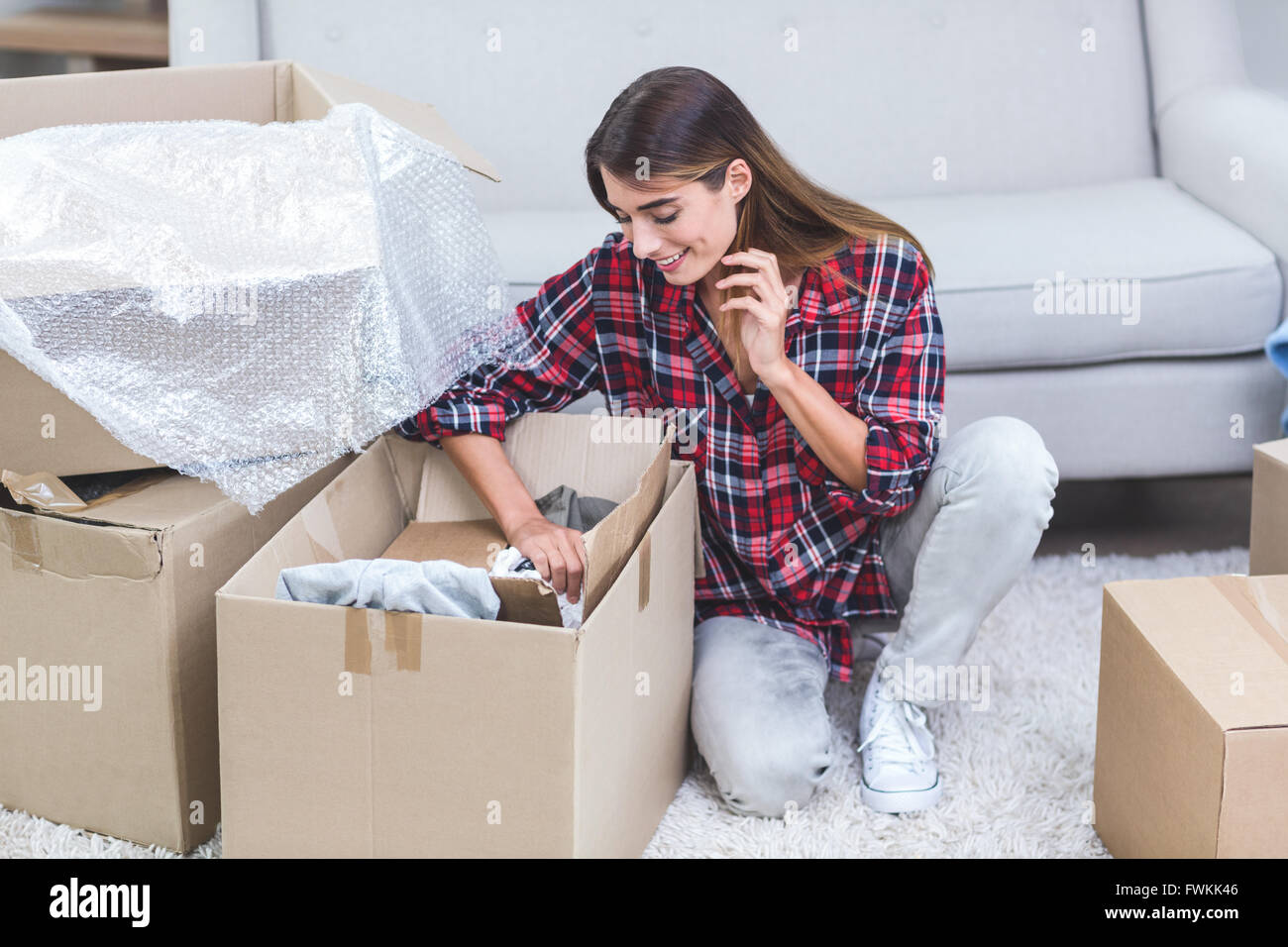 Beautiful woman unpacking carton boxes Stock Photo - Alamy