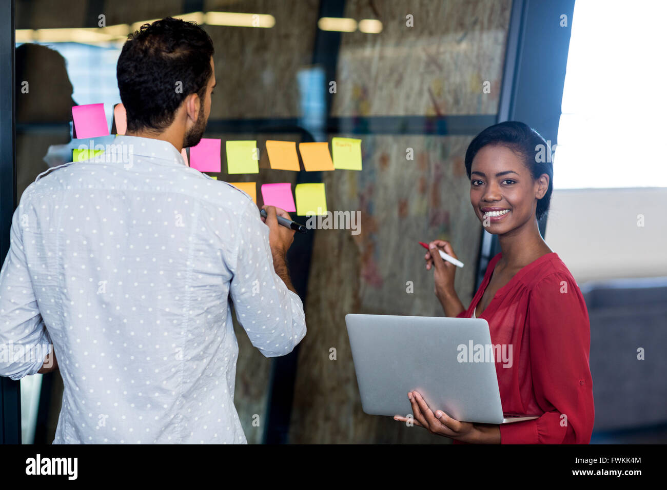 Colleagues writing on sticky notes Stock Photo - Alamy