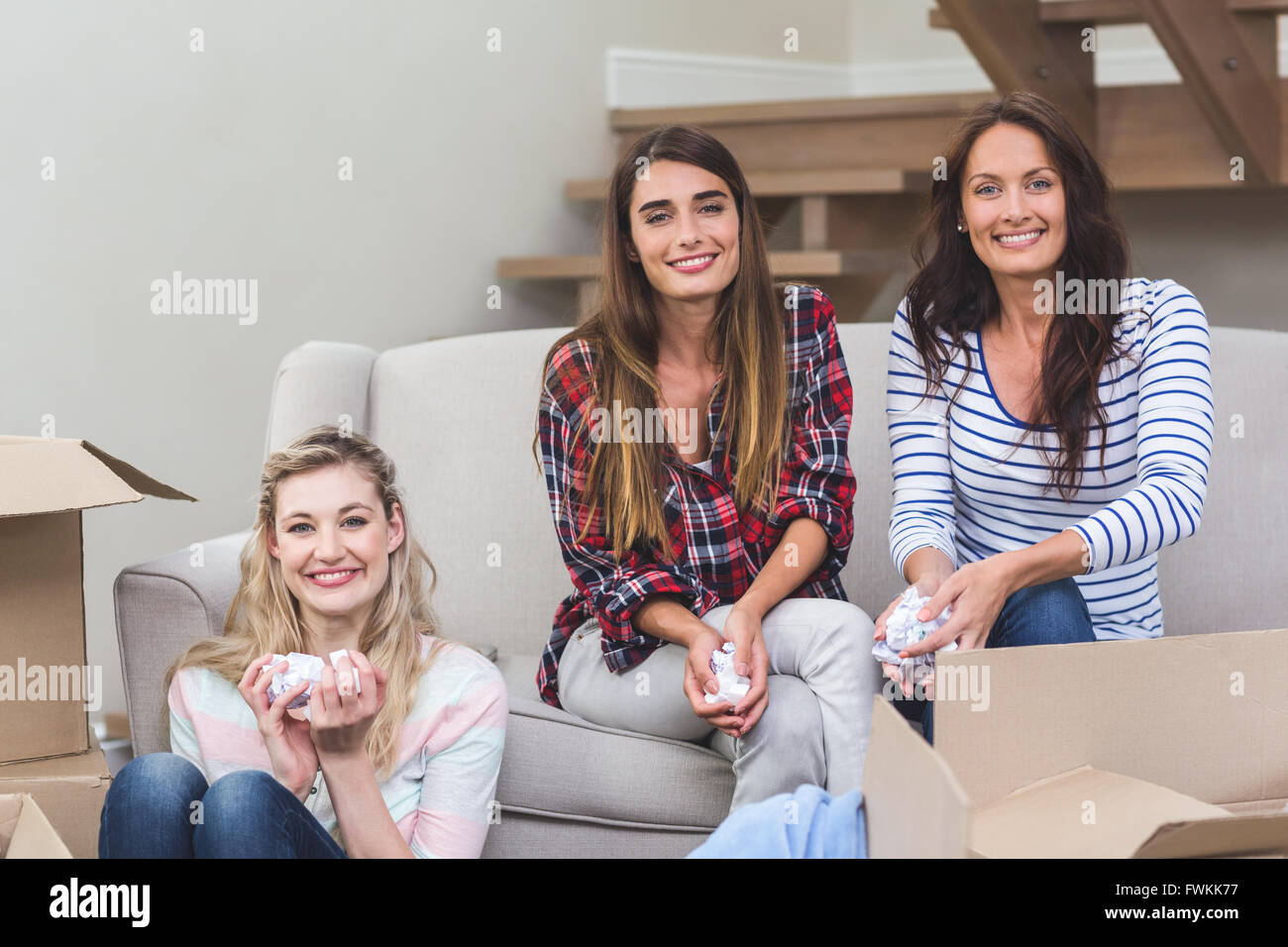 Friends holding packing peanuts in their new house Stock Photo - Alamy