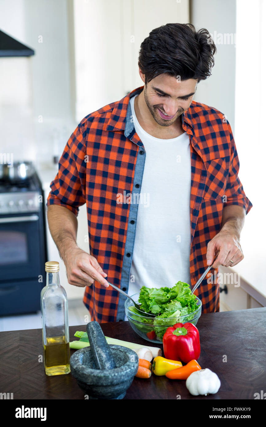 Portrait of man mixing a salad in kitchen Stock Photo - Alamy