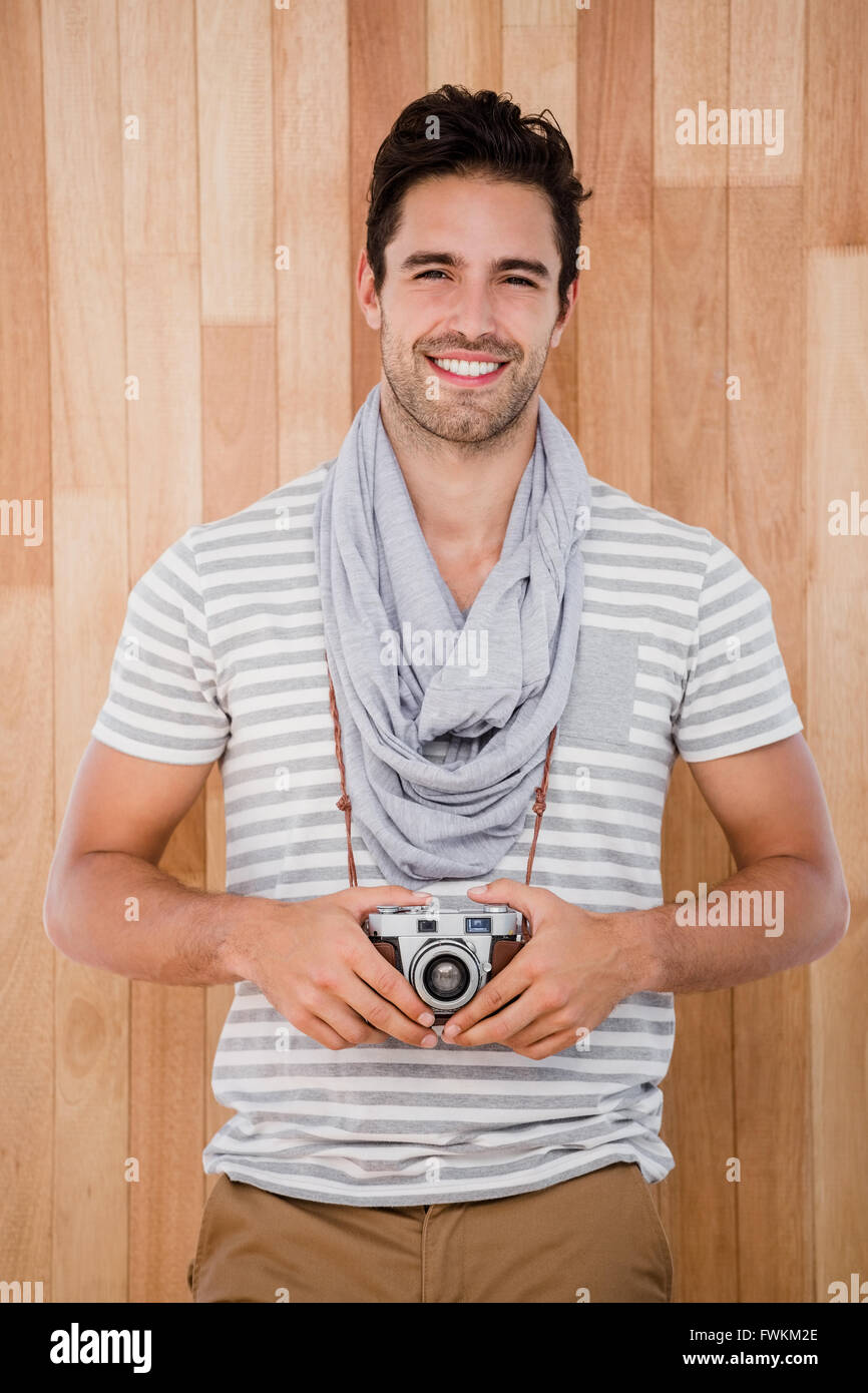 Smiling man standing with a camera Stock Photo - Alamy