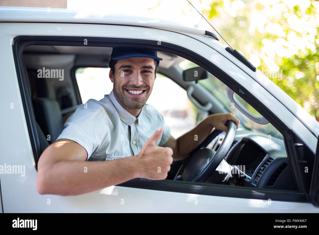 Cheerful delivery man showing thumbs up Stock Photo - Alamy